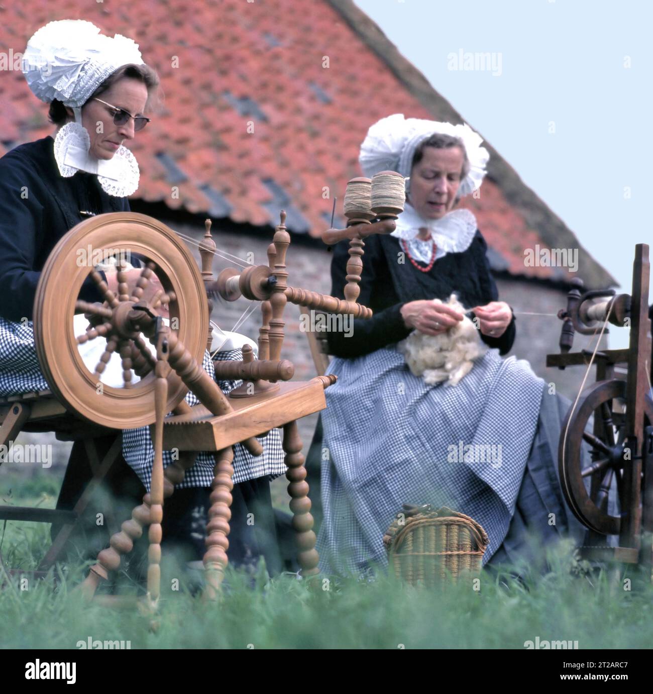 EDE,HOLLAND-JUNE 11,2022: Craftswomen using an old spinning wheel to ...