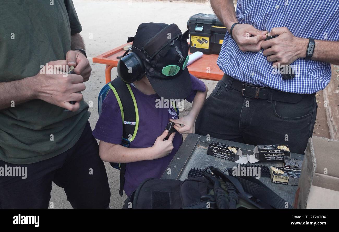 Israeli civilians load pistols at the shooting range of Caliber 3 ...