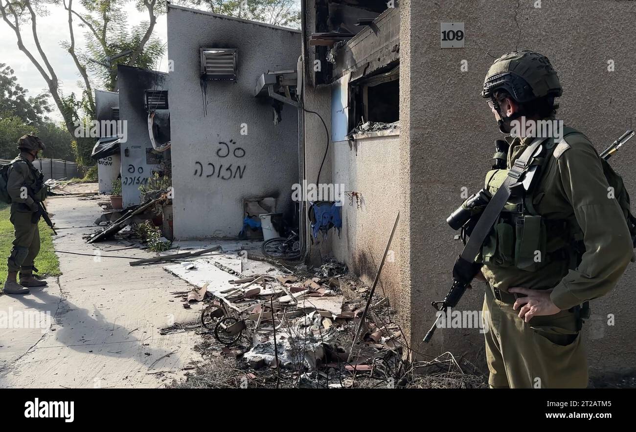 An Israeli soldier stands guard next to houses damaged in a battle ...
