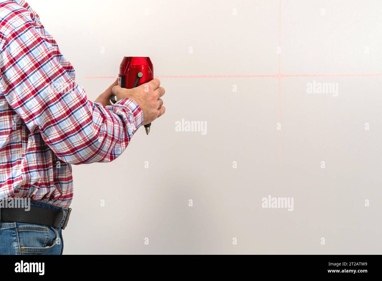 Builder man with laser level. measuring with red laser level ...