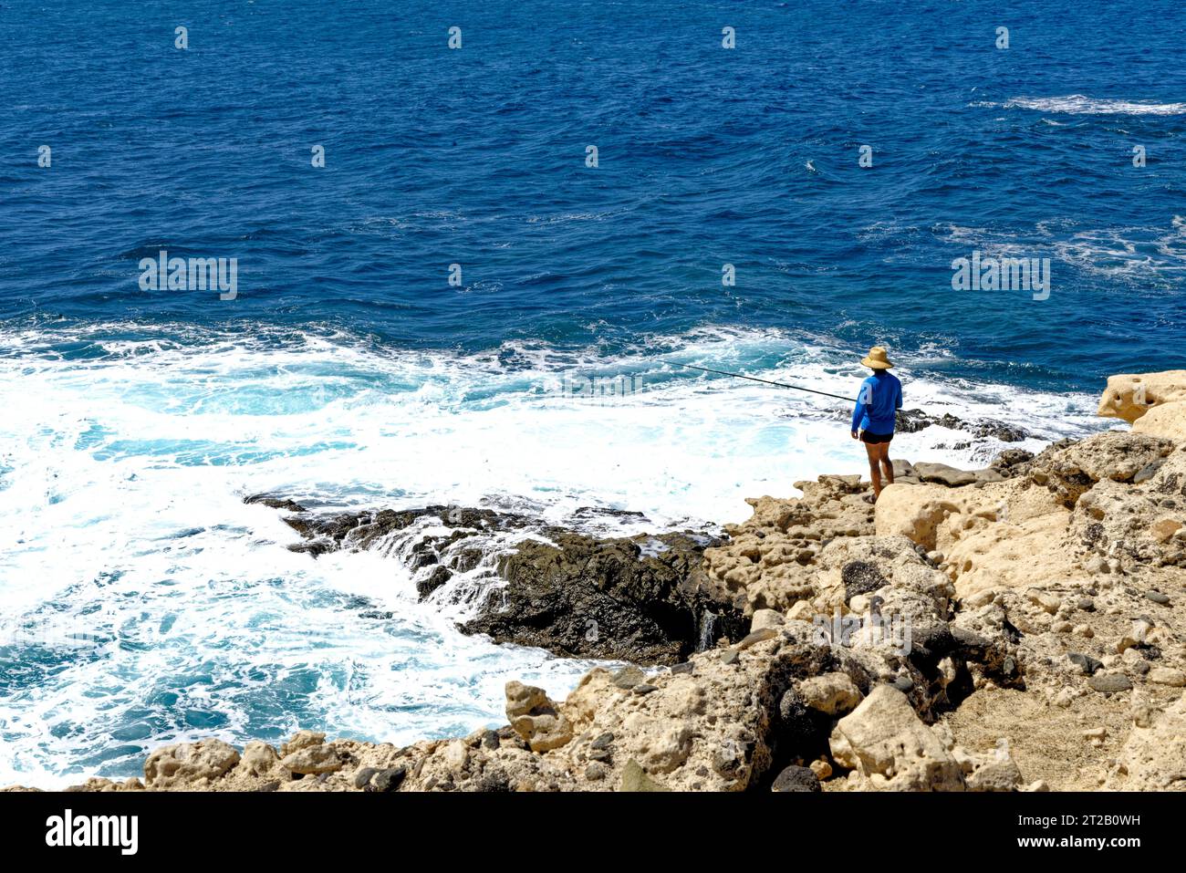 Fisherman at Caves near the seaside village of Ajuy on the west coast ...