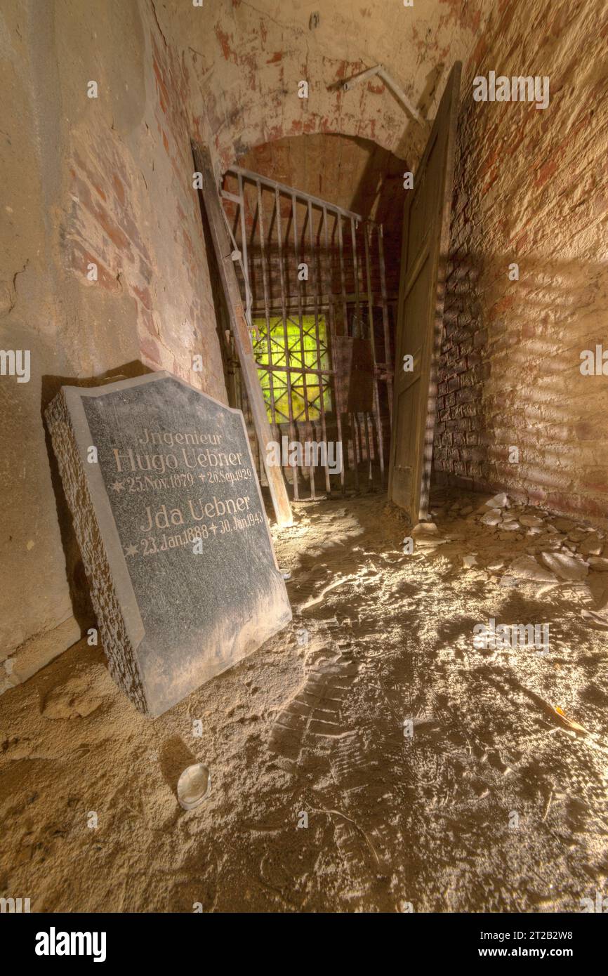 An old stone memorial in an abandoned prison cell block area, with a ...