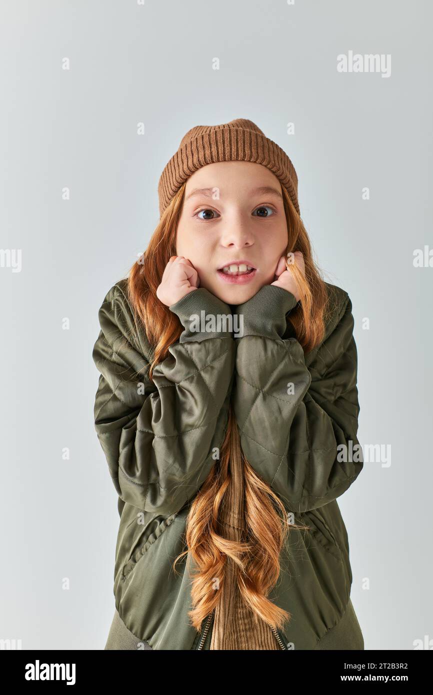 girl in winter outfit with knitted hat feeling cold and standing on ...