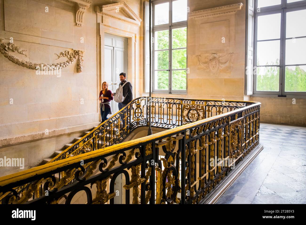 Two people wander through the Domaine de Marie-Antoinette, also known ...