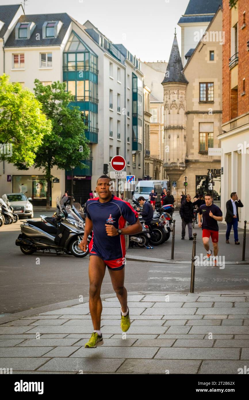 A group of runners jog through the streets of Le Marais neighbourhood ...