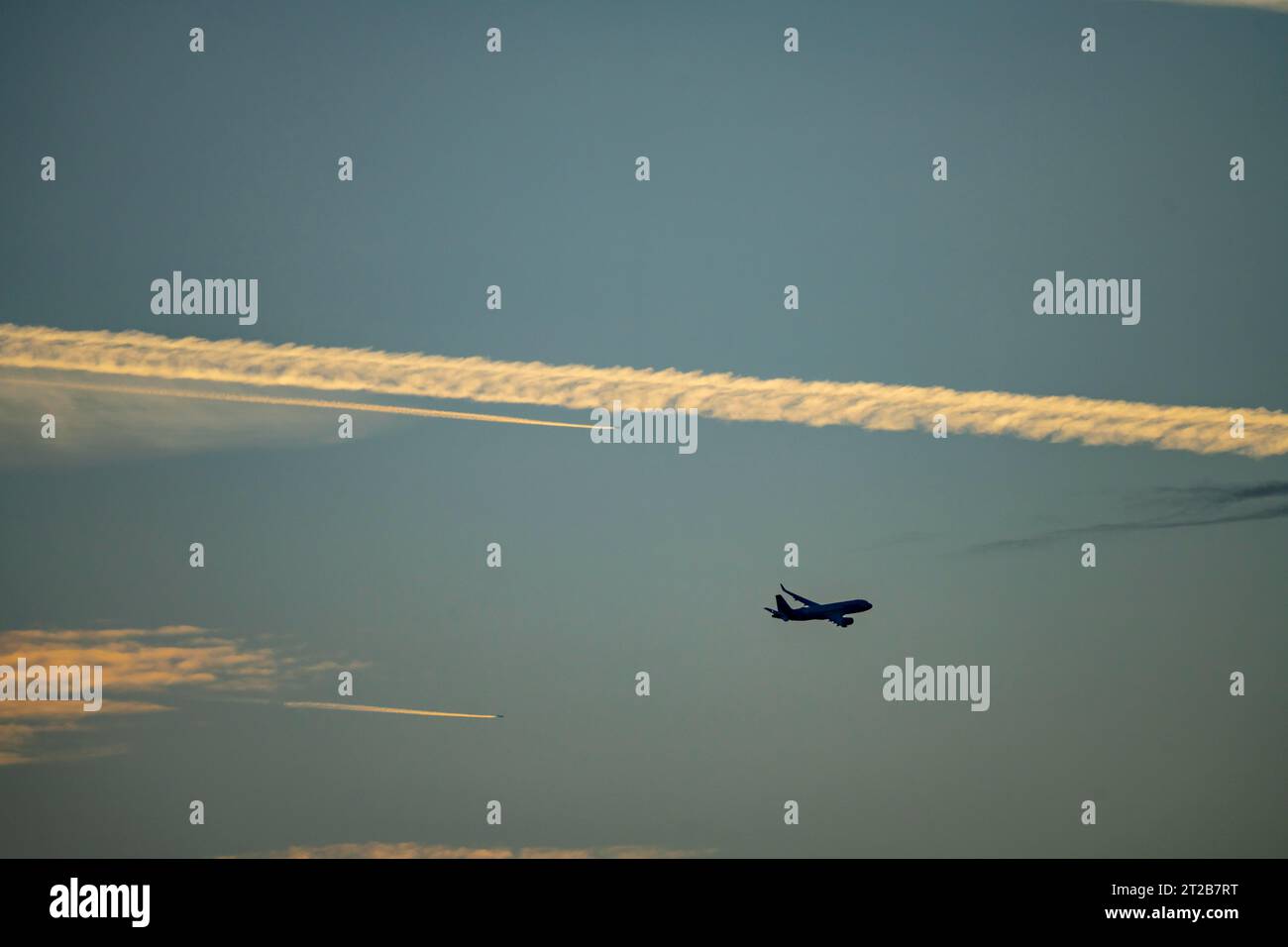 Passenger aircraft with contrails hi-res stock photography and images ...