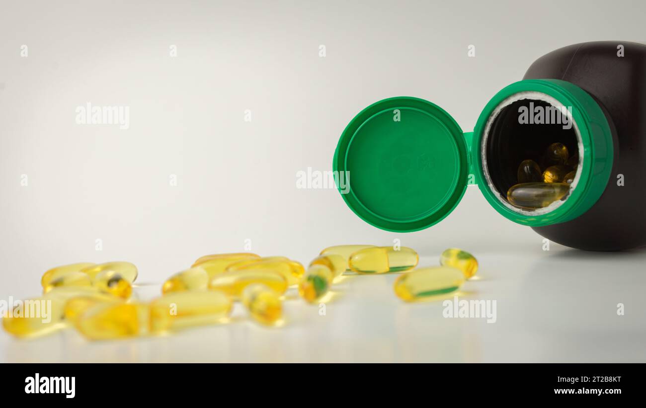 Omega-3-rich wild salmon and fish oil capsules spilling out from the ...