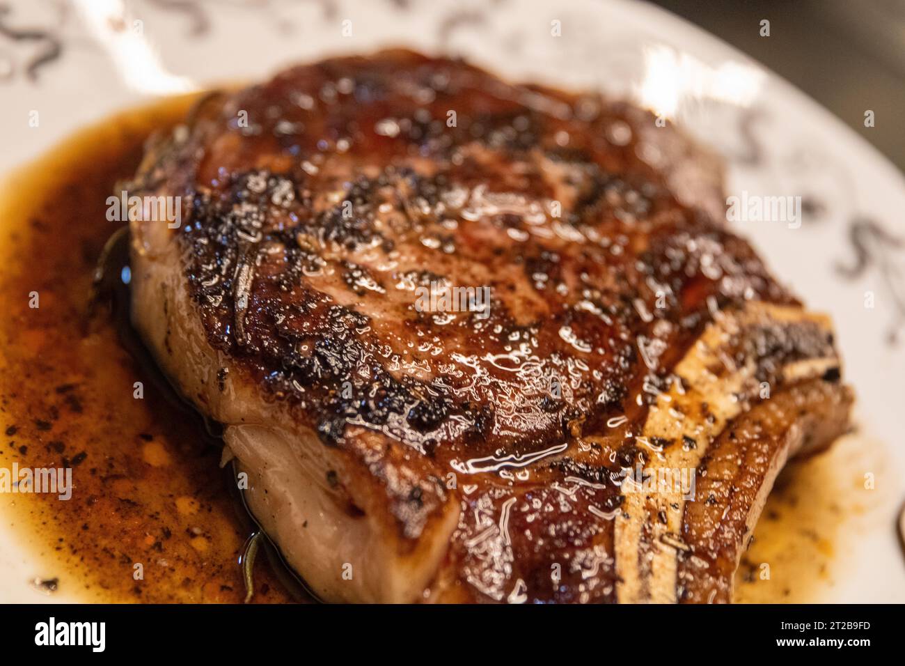 Bone In Seared Ribeye plated with juices Stock Photo - Alamy