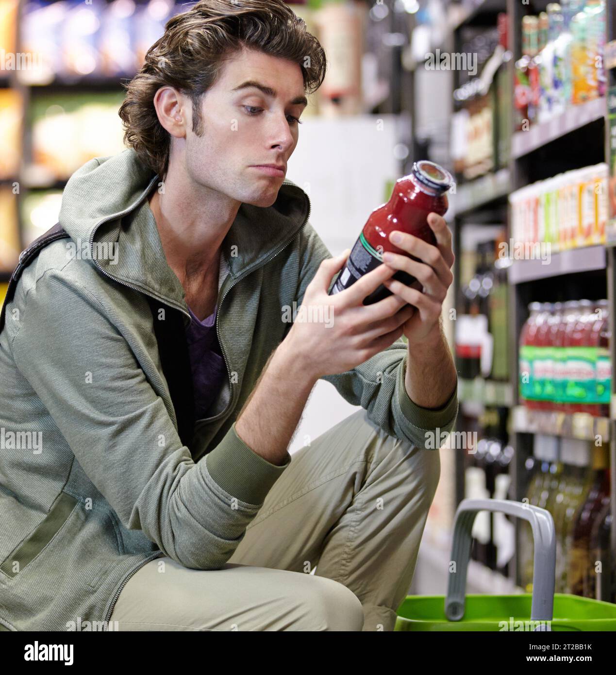 Man, label and product in supermarket for decision, consider or grocery ...