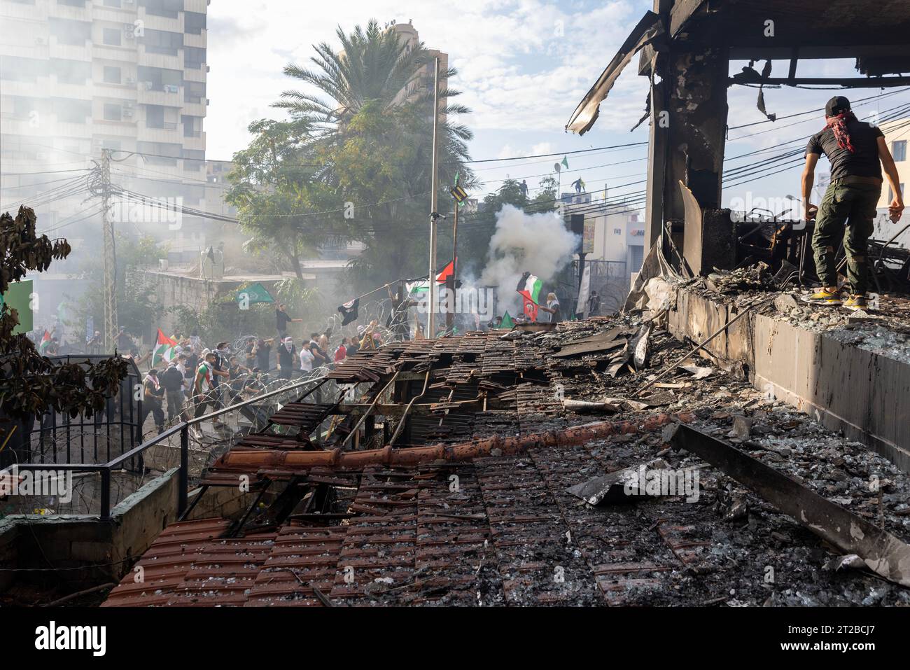 Awkar, Lebanon. 18th Oct, 2023. A demonstrator carries climbs into a ...