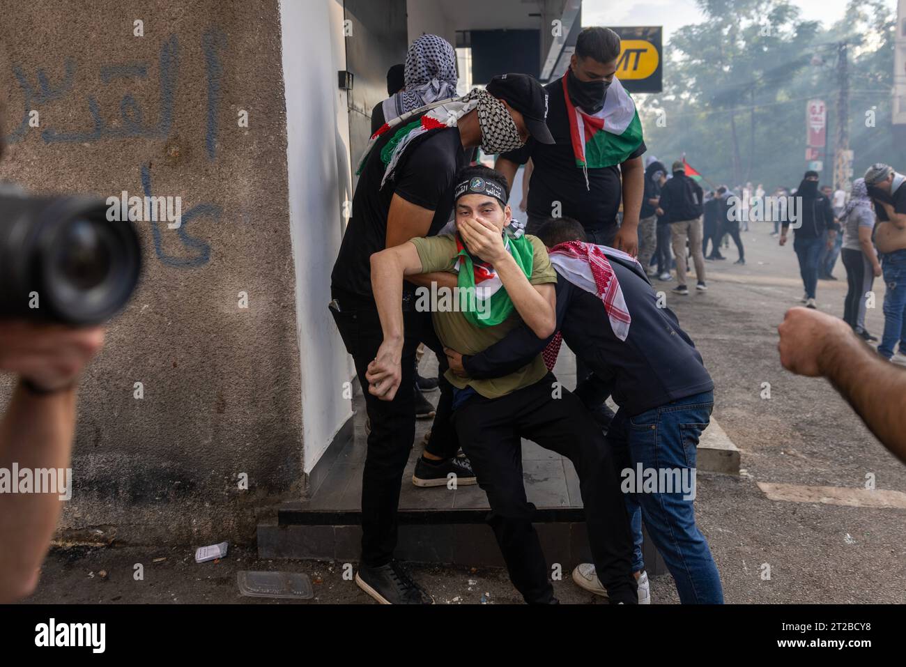 Awkar, Lebanon. 18th Oct, 2023. A wounded demonstrator is carried by ...