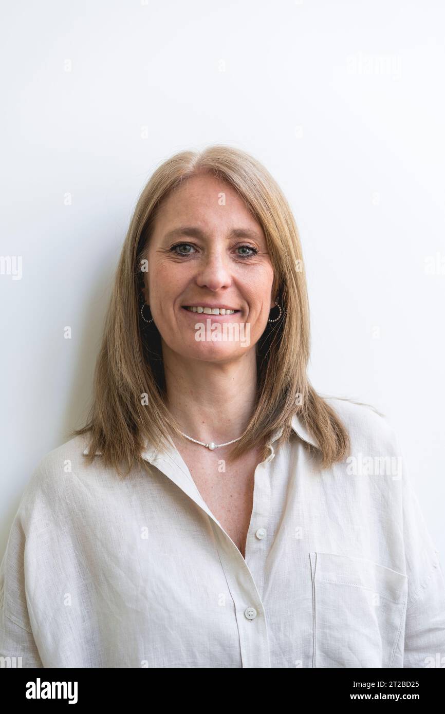 Beautiful mid aged woman looking at camera leaning on white wall Stock ...