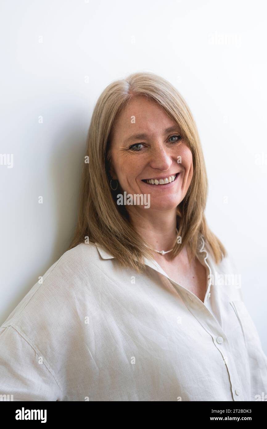 Beautiful mid aged woman looking at camera isolated on white background ...