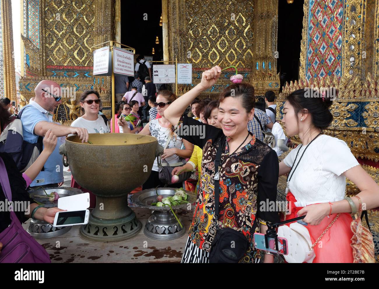 Tourists with lotus flower bathed in holy water for protection and ...