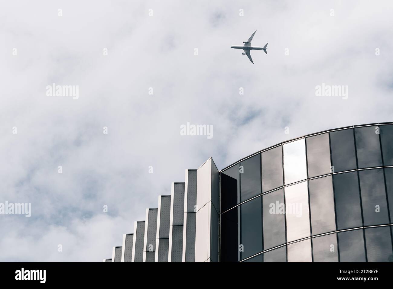 Plane over skyscrapers in the city of London. Low angle view against ...