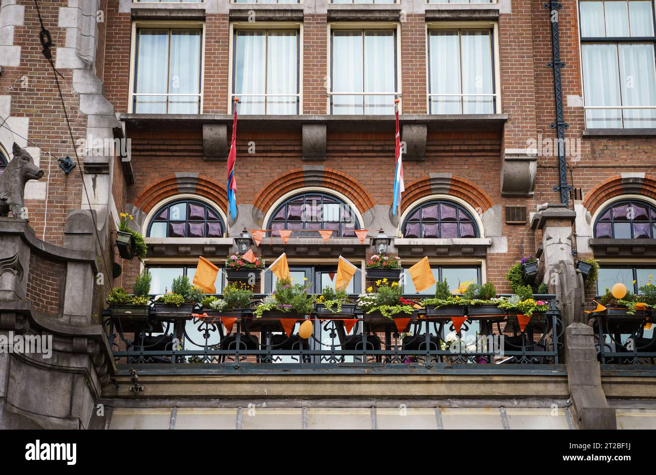 Building facade decorate with orange flag on King's Day. AMSTERDAM ...
