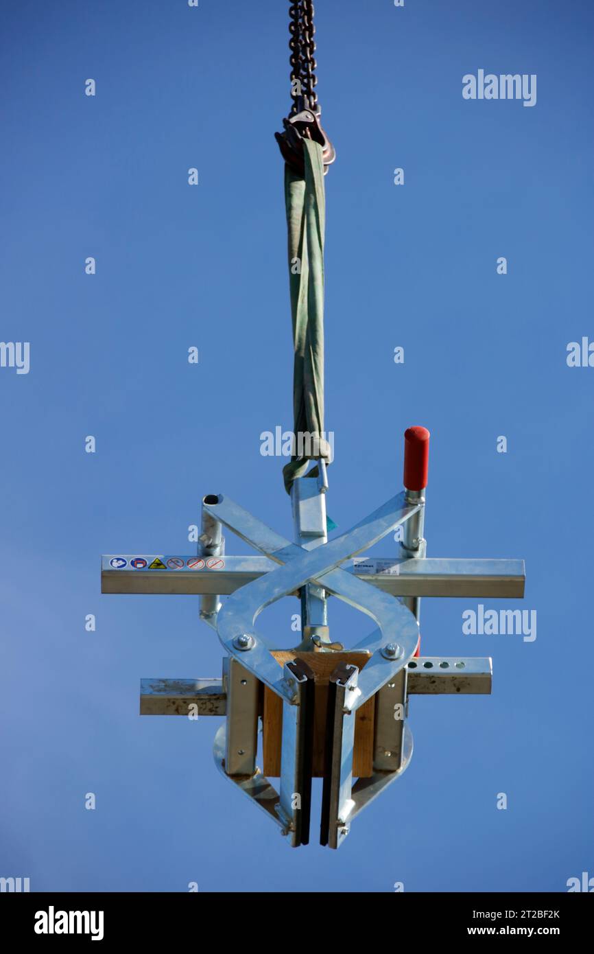 Wooden beam lifting tongs hang on a crane Stock Photo - Alamy