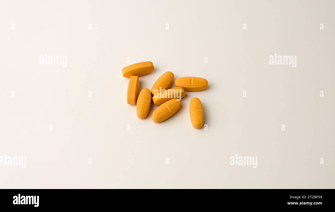 Multivitamin supplement pills set against a neutral off-white backdrop ...