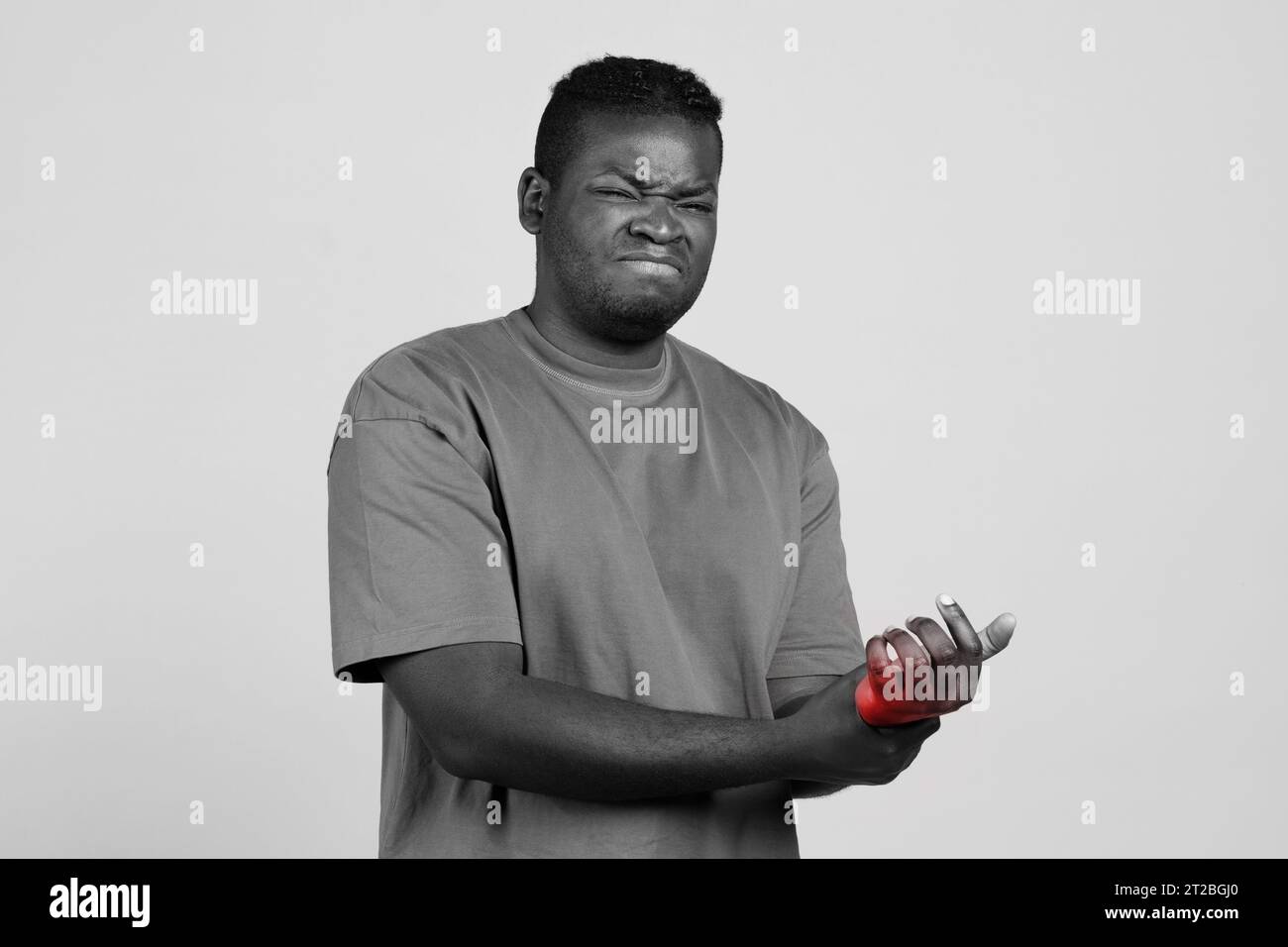 African guy suffering from wrist pain touching red spot, studio Stock ...