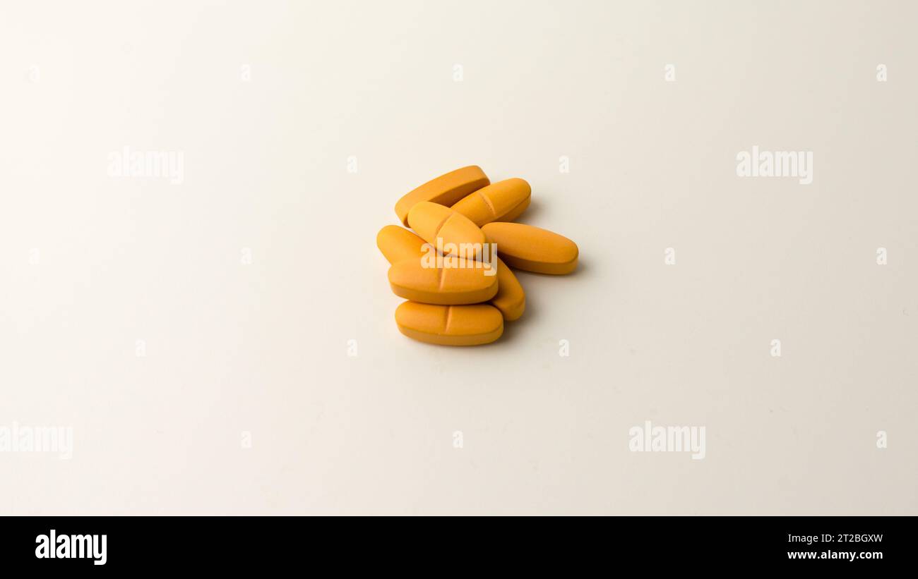 Multivitamin supplement pills set against a neutral off-white backdrop ...