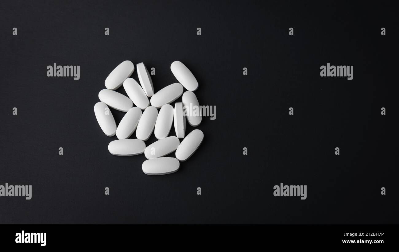 Calcium supplement pills on black background Stock Photo - Alamy