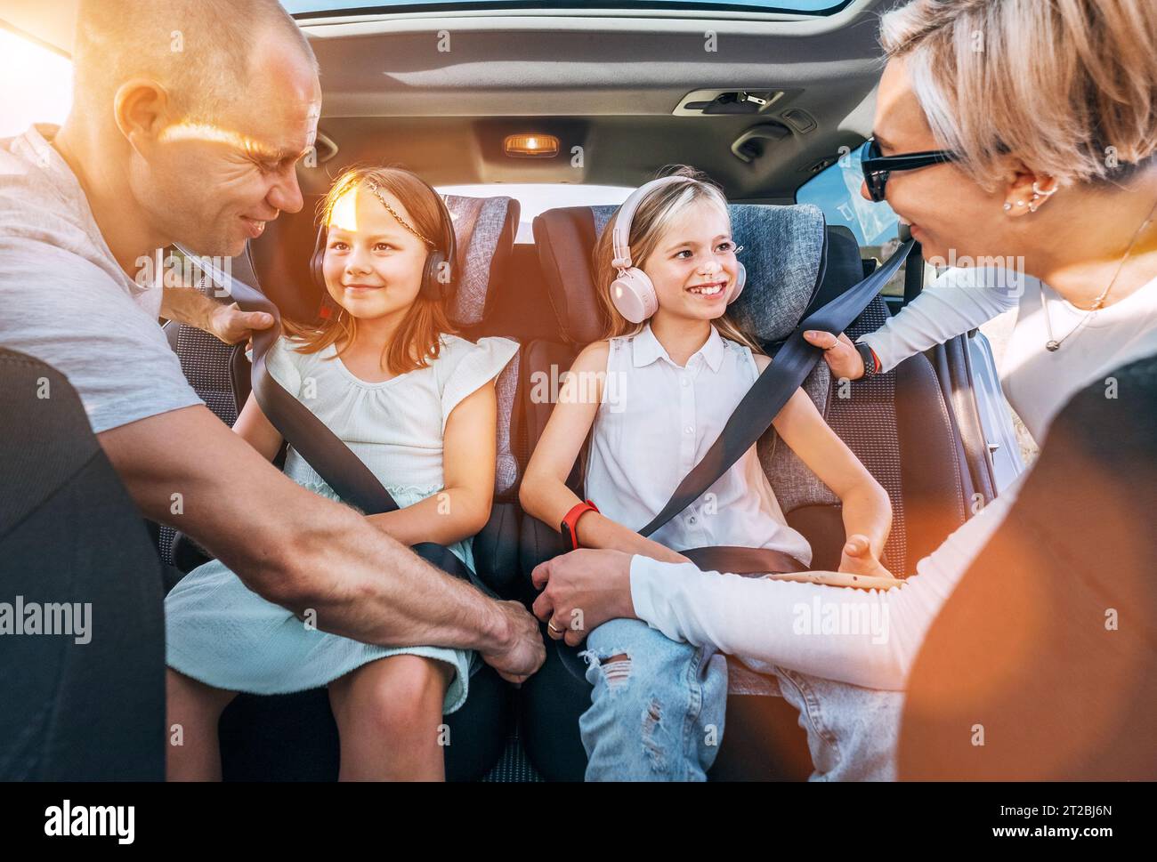 Inside car photo of mother and father fastening with safety auto belts ...
