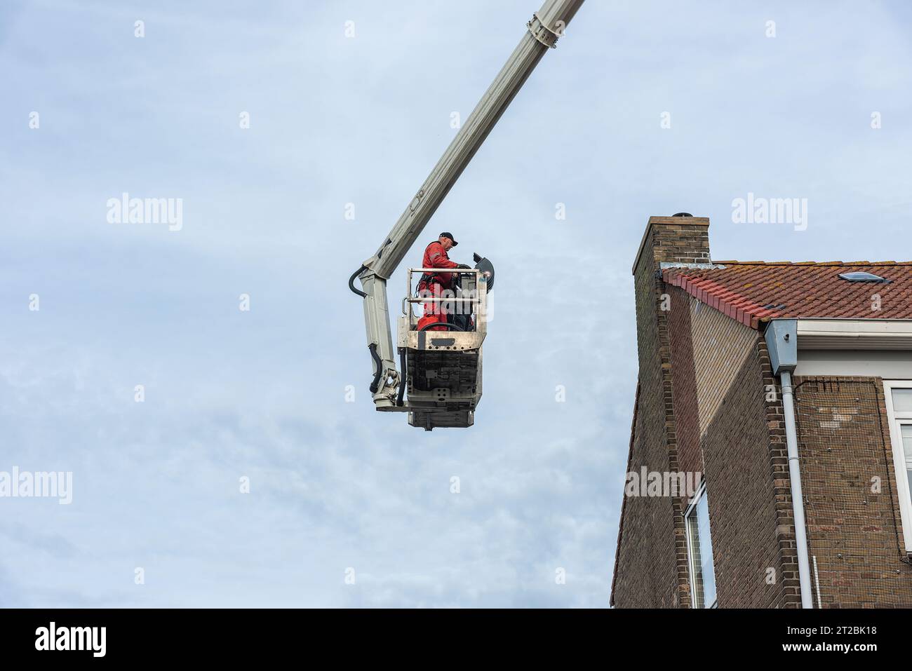 man stand on the platform of an aerial platform above an apartment ...