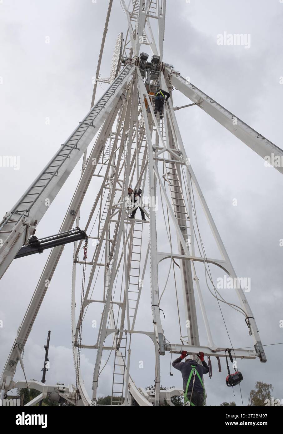 Looking up at the big wheel being dismantled by fairground staff after ...