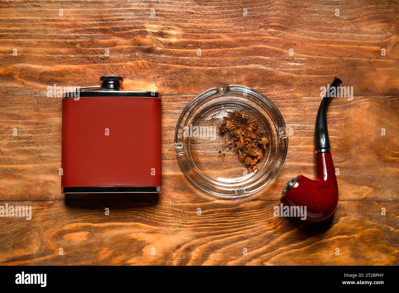 New hip flask, smoking pipe and ash tray with tobacco on wooden ...