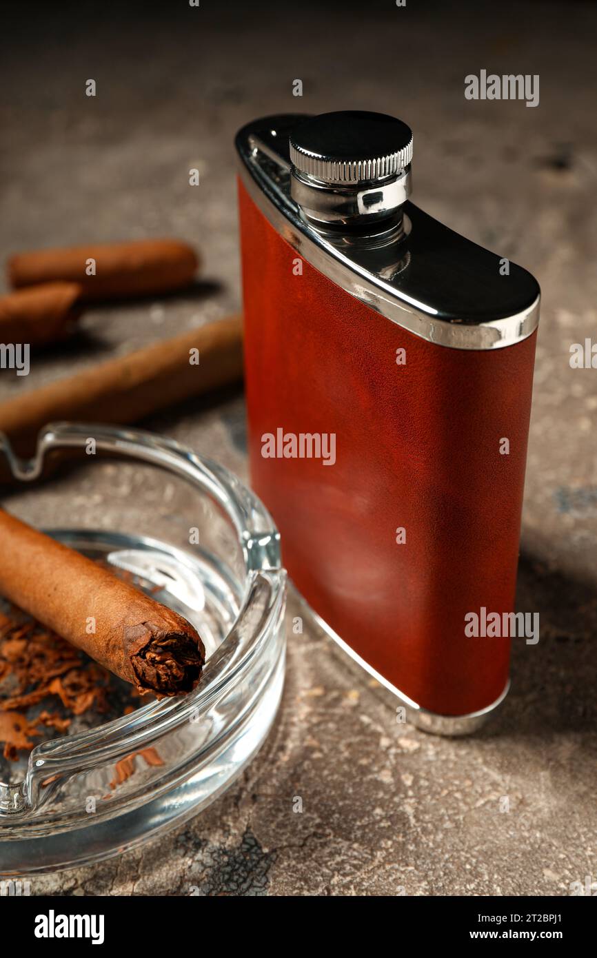 New hip flask and ash tray with cigar on grunge background Stock Photo ...