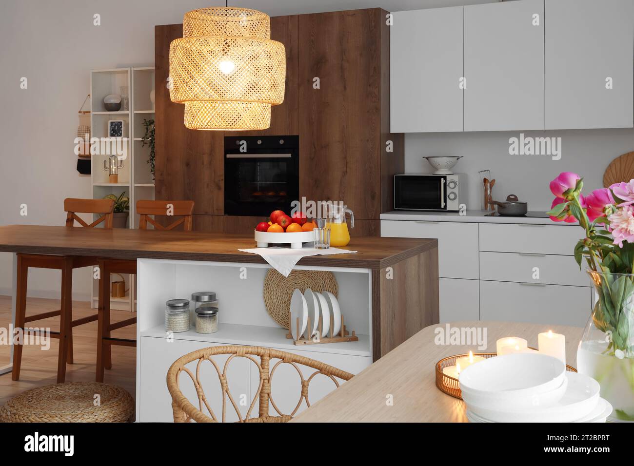 Interior of modern kitchen with dining table, island and glowing lamps ...