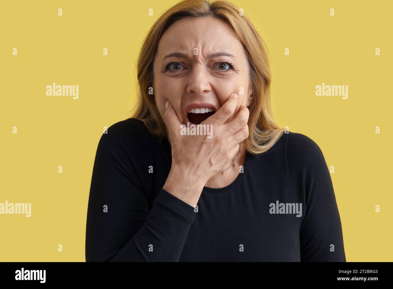 Scared mature woman on yellow background, closeup Stock Photo - Alamy