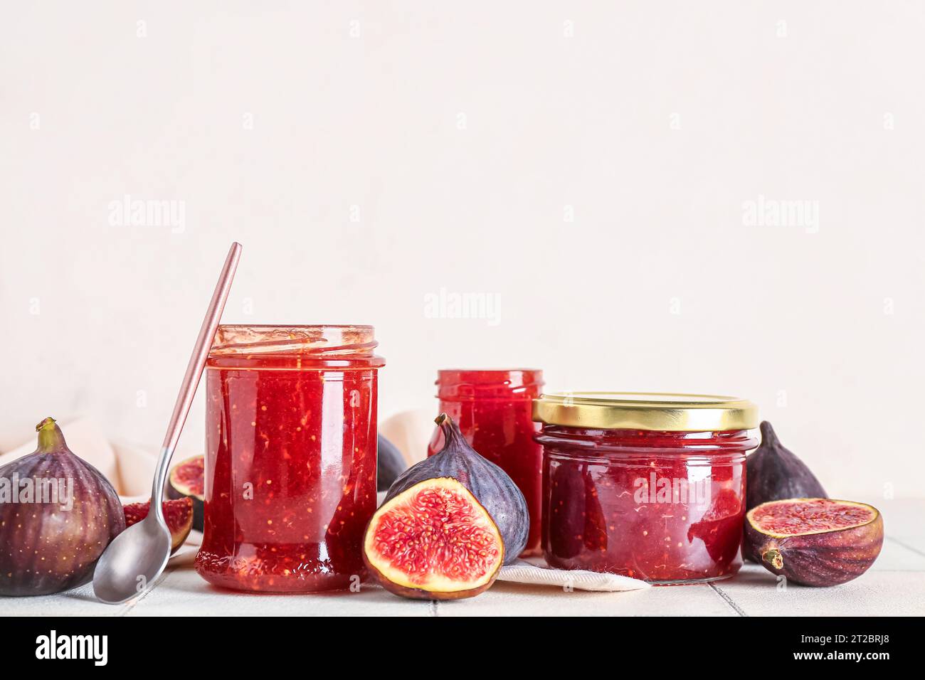 Jars of sweet fig jam on white tile table Stock Photo - Alamy