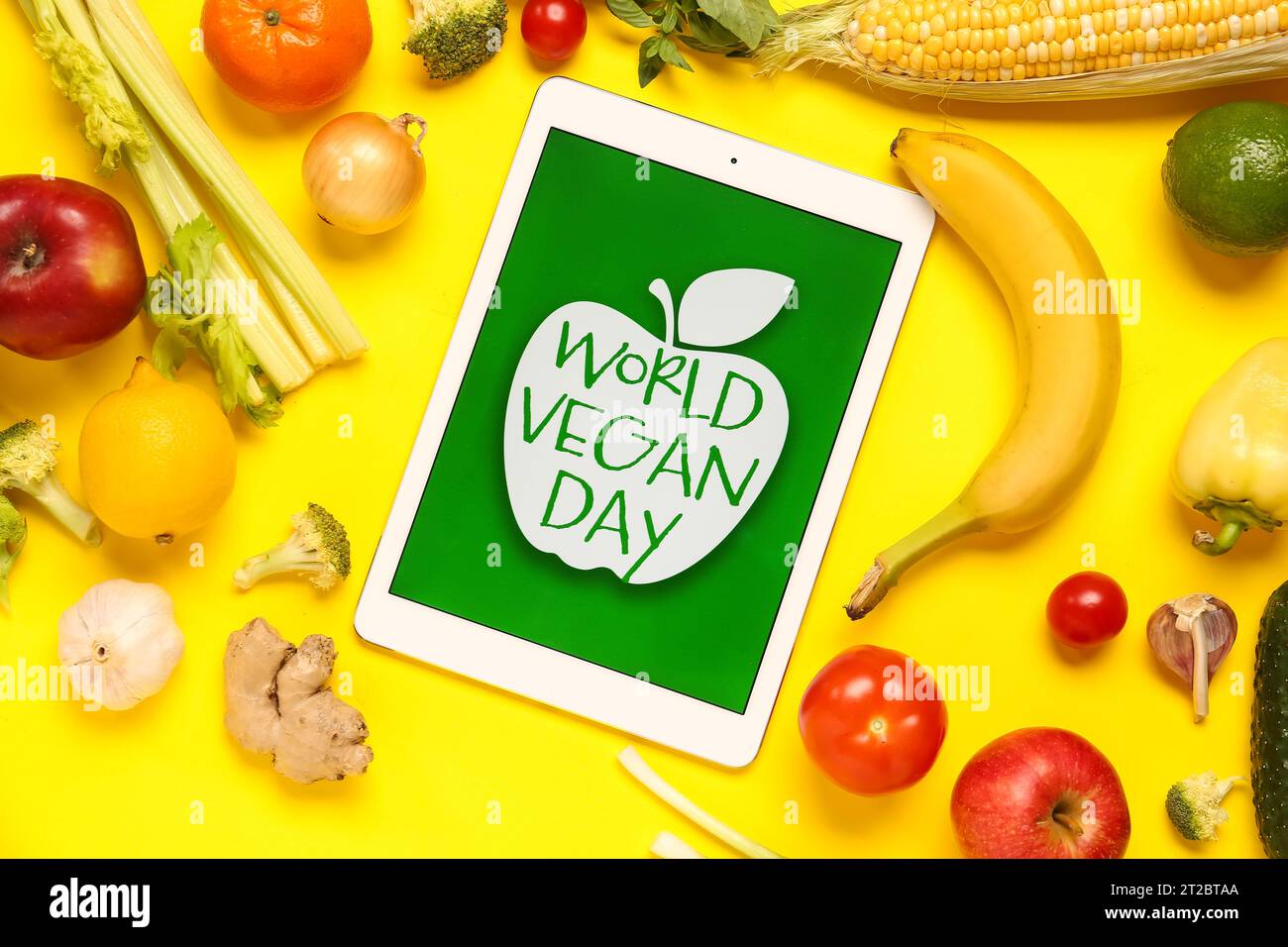 Tablet computer with text WORLD VEGAN DAY, fresh vegetables and fruits ...