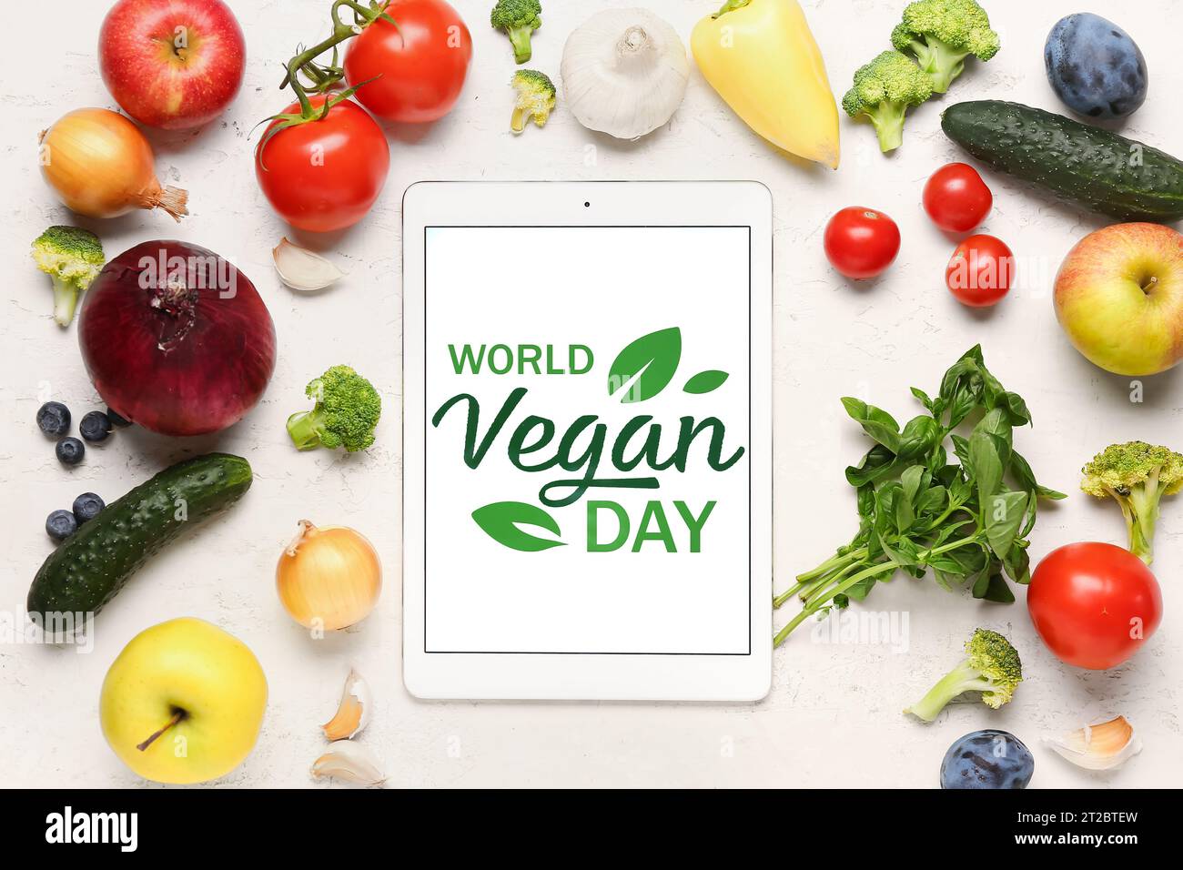 Tablet computer with text WORLD VEGAN DAY, fresh vegetables and fruits ...