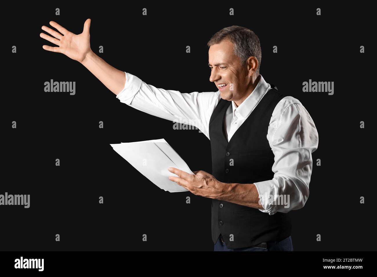 Mature actor reading film script on dark background Stock Photo - Alamy