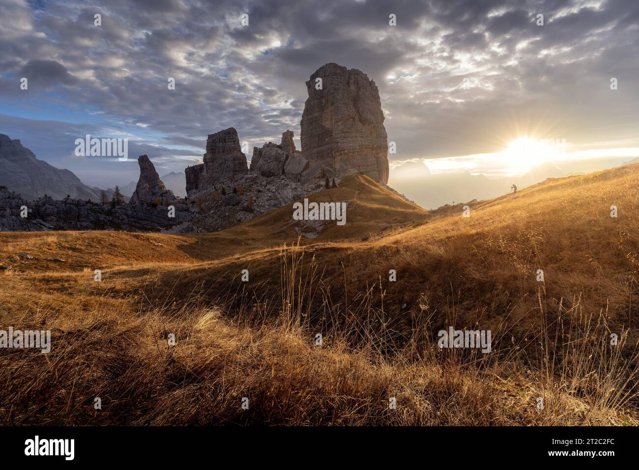 Sun rising above beautiful autumn landscape with towering mountain in ...