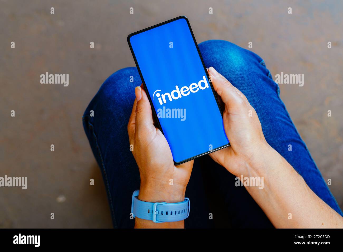 In this photo illustration, the Indeed logo is displayed on a ...