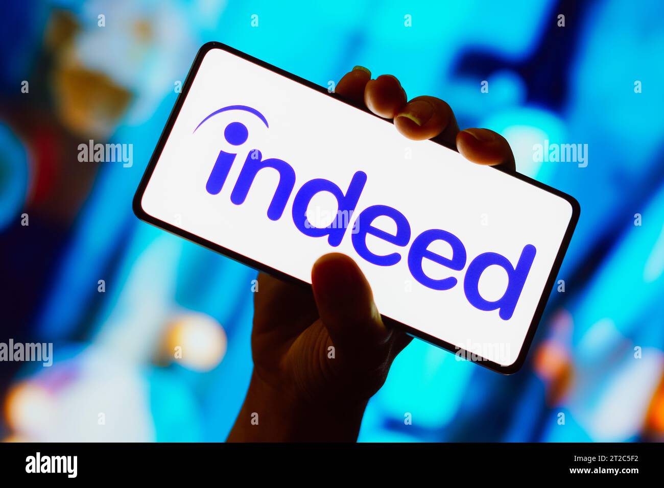 In this photo illustration, the Indeed logo is displayed on a ...