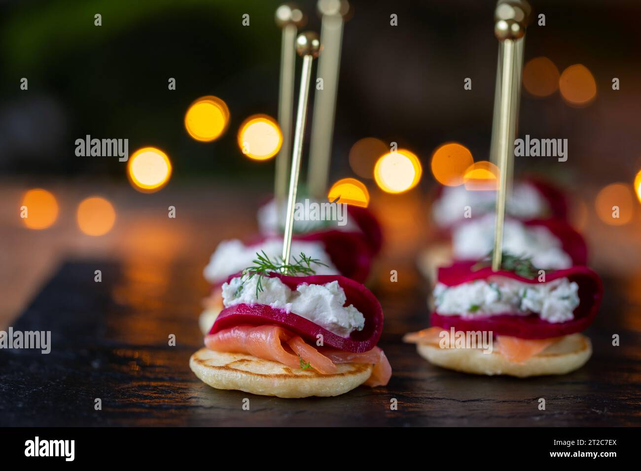 Christmas canapes with blinis with salmon, pickled beetroot and goat ...