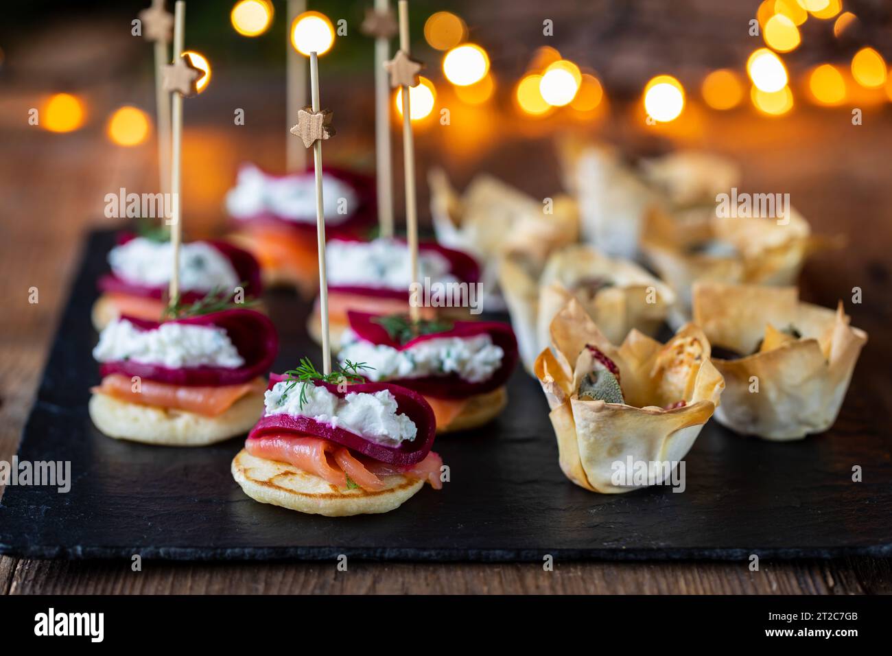 Christmas canapes with blinis with salmon, beetroot and goat cheese and ...