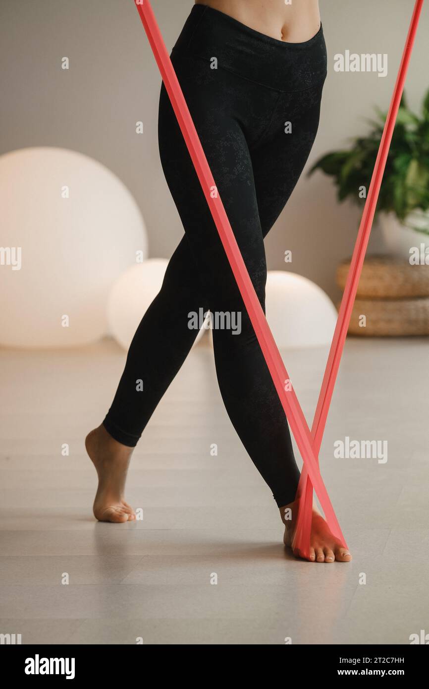 Close-up of the legs of a Girl in black doing fitness with red ribbons ...