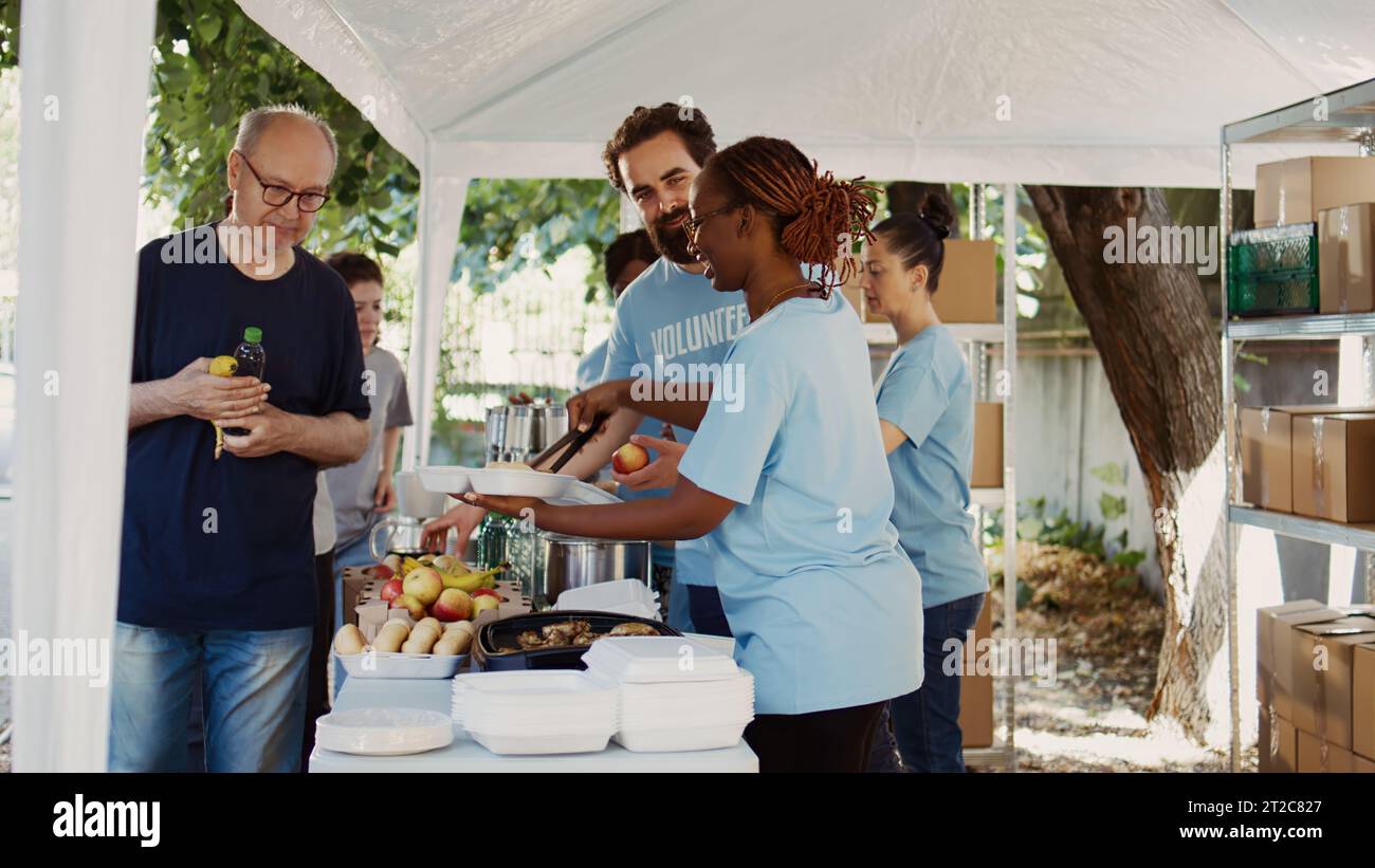 Side-view of charity workers providing warm meals to the poor and needy ... Side-view of charity workers providing warm meals to the poor and needy ...