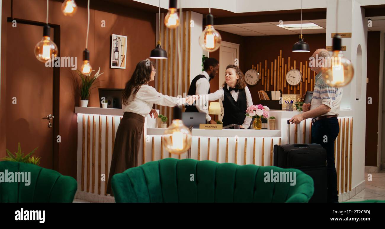 Hotel staff offering access key card to room reservation upon their ...