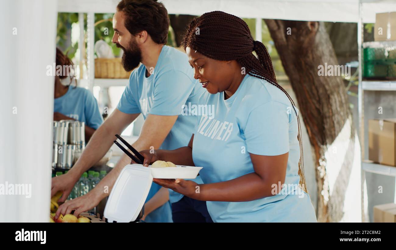 Black woman serving meals to underprivileged at community outreach ...