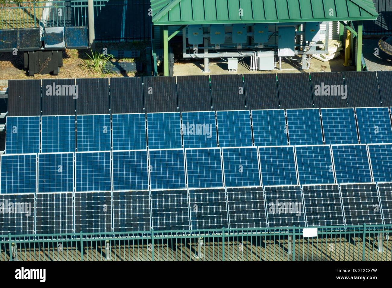 Aerial view of blue solar photovoltaic panels mounted on fenced ...