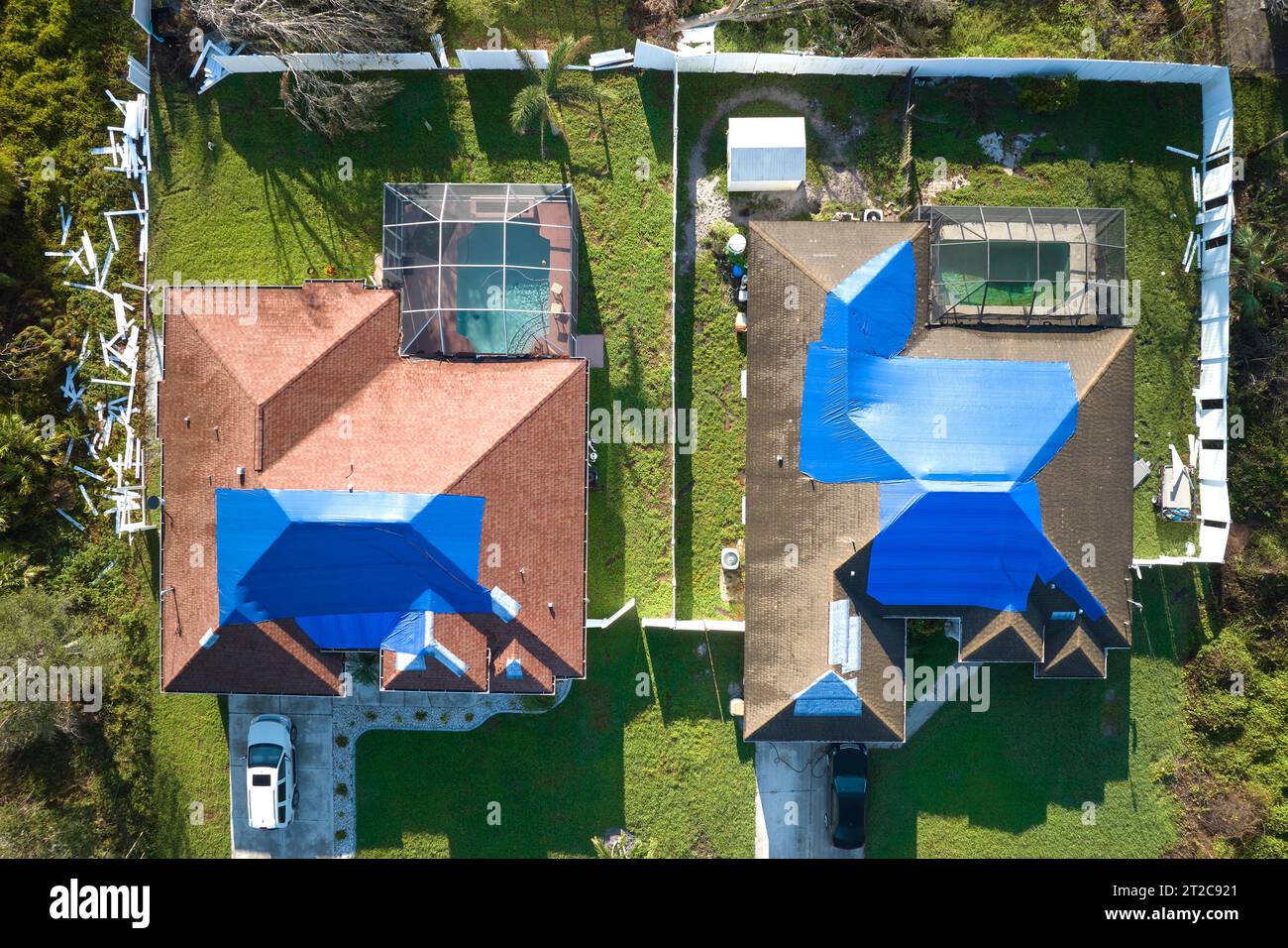 Aerial view of damaged in hurricane Ian house roof covered with blue ...