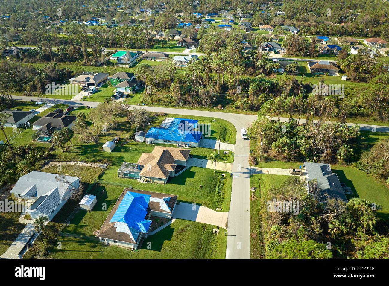 Aerial view of damaged in hurricane Ian house roof covered with blue ...