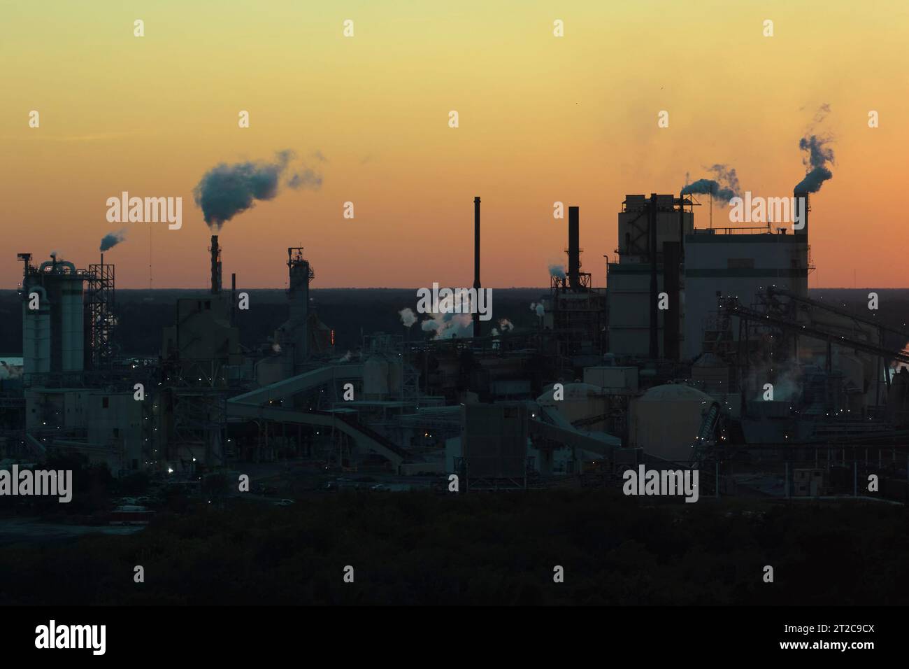 Aerial view of large factory with smokestack from production process ...