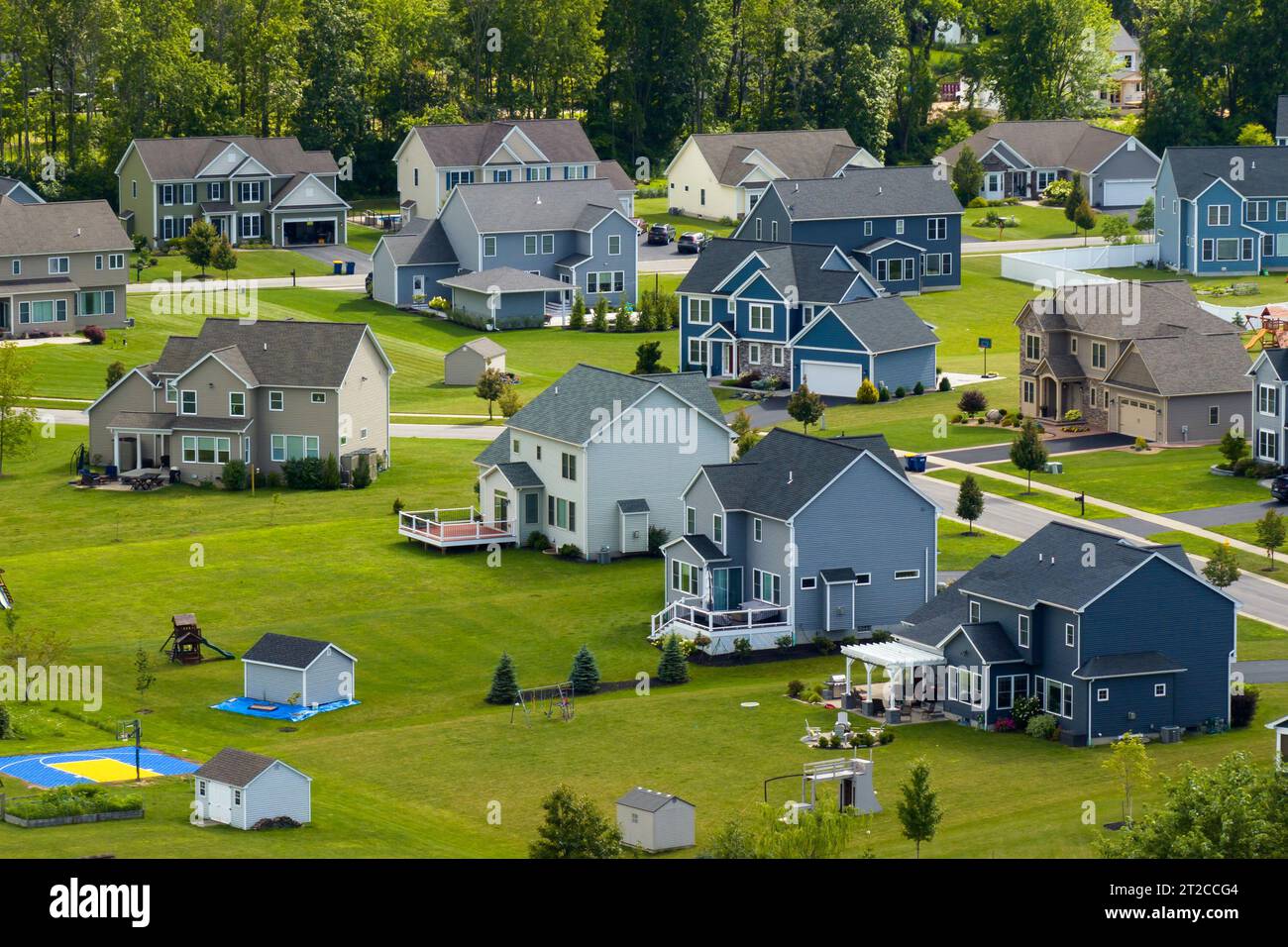 Upscale suburban homes with large backyards and green grassy lawns in ...